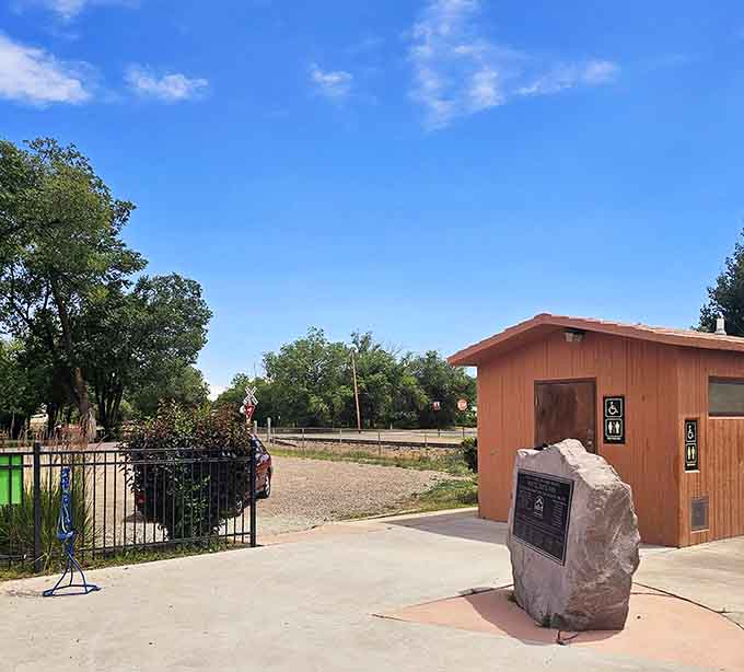 Memorial plaques honor community history beside shaded pathways, where past and present peacefully coexist in quiet dignity.