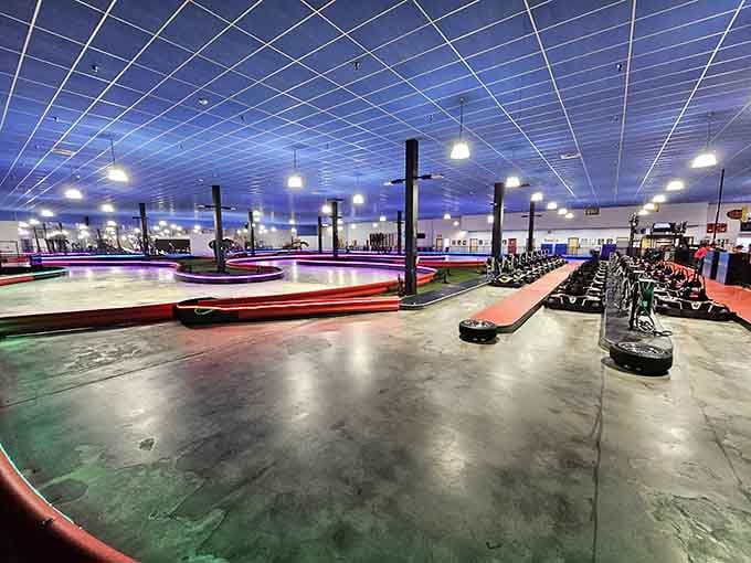 The go-kart track sprawls beneath blue lighting, creating an atmosphere that screams "start your engines!"