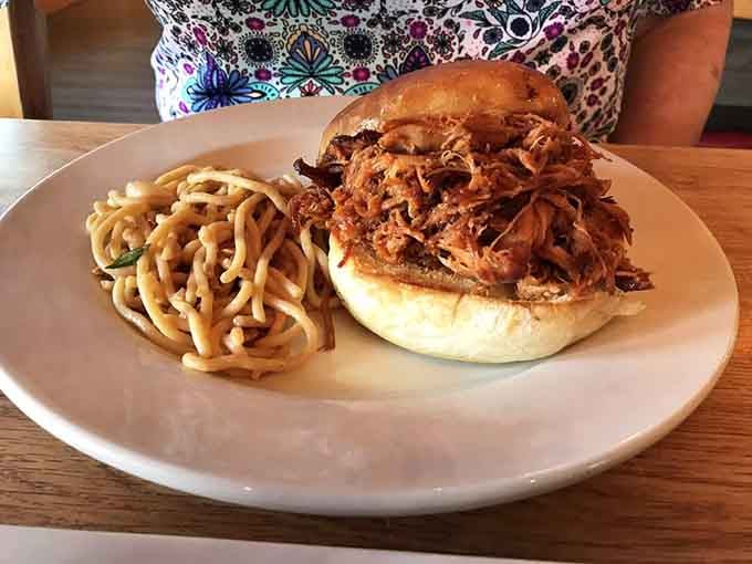 Pulled pork piled high enough to require structural engineering, served with fries that know their supporting role perfectly well.