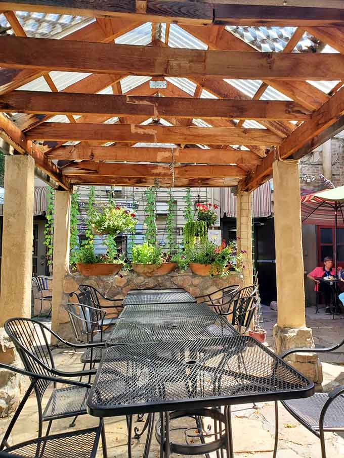 Outdoor patio dining under wooden beams and hanging plants, where Colorado sunshine meets good food and conversation.