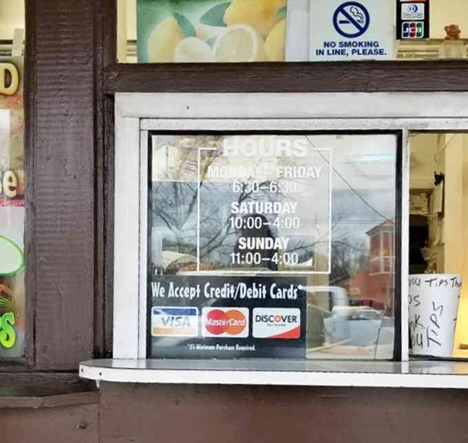 Operating hours posted clearly because transparency matters, even in the burger business where honesty still counts for something.