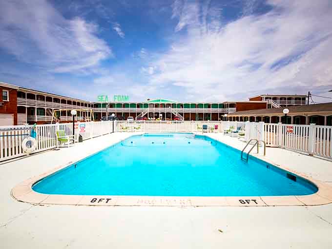 The pool beckons with that classic kidney shape, perfect for cooling off after a long day of serious beach lounging.