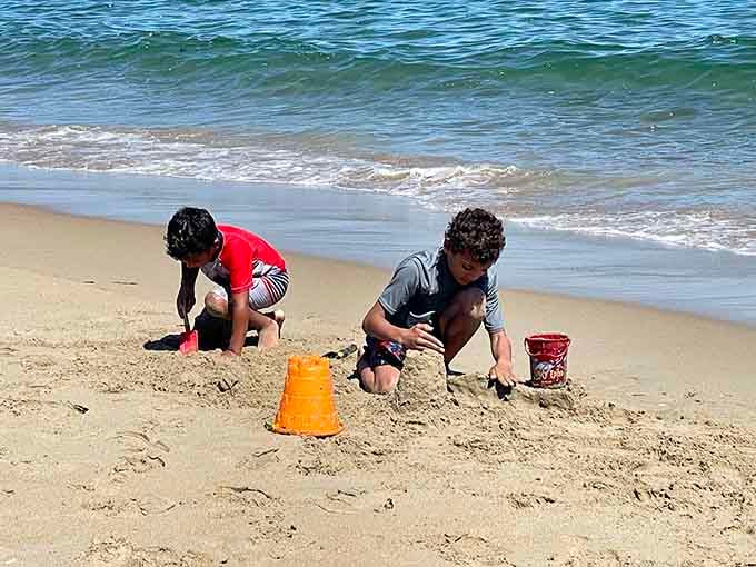 Young architects construct sandy masterpieces with serious concentration, building memories that outlast any castle's walls.