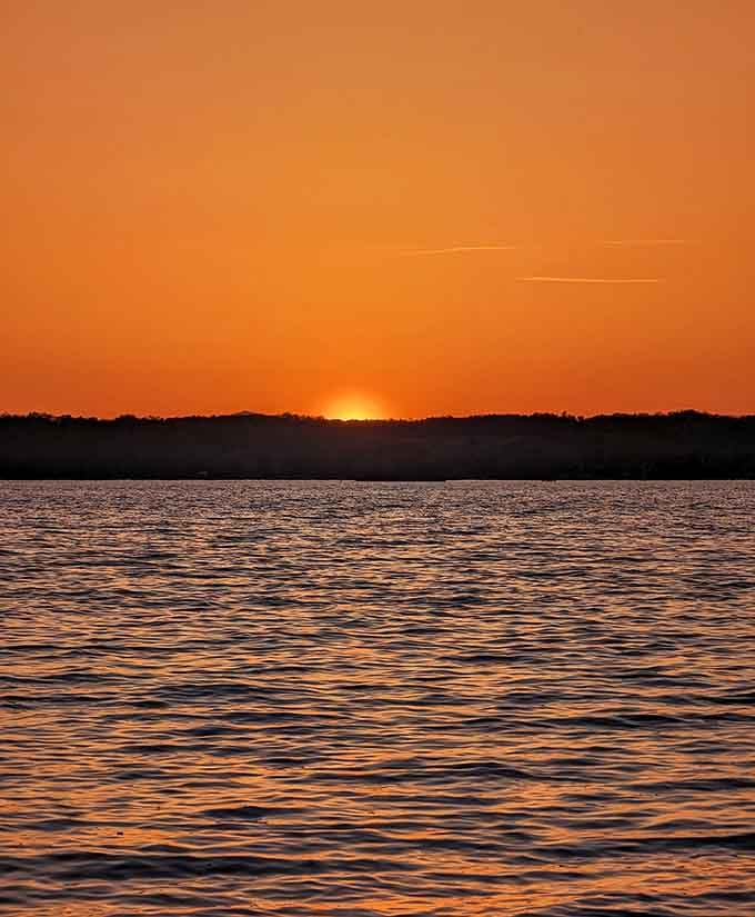Sunset paints the water in fiery oranges, proving landlocked beaches do spectacular endings too.