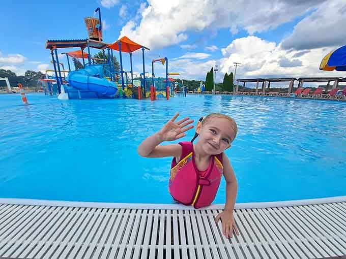 Pure joy captured in one enthusiastic wave, this young swimmer embodies everything magical about summer days.