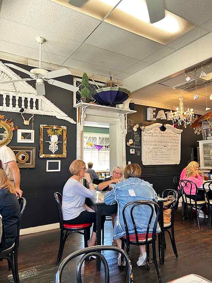 Black accent walls and vintage chandeliers prove that tea rooms don't have to be all pastels and boring predictability.