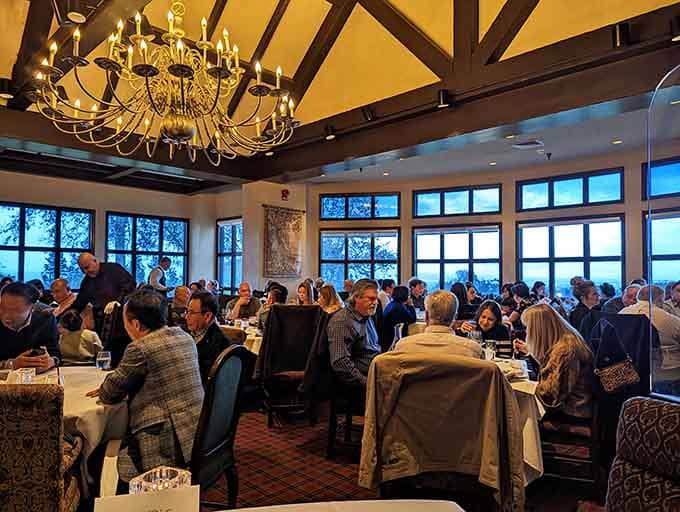 Full dining room with ocean views through those windows, proof that good food attracts good company consistently.