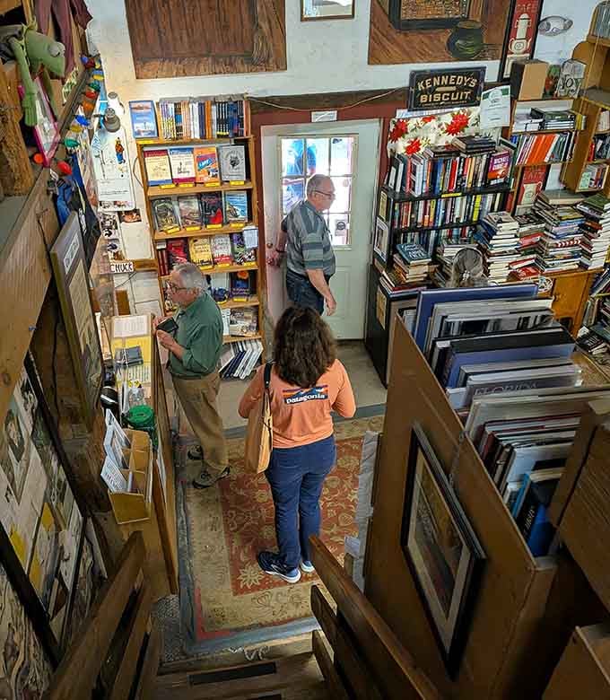 Overhead view captures book lovers in their natural habitat, navigating narrow aisles with practiced determination and focus.