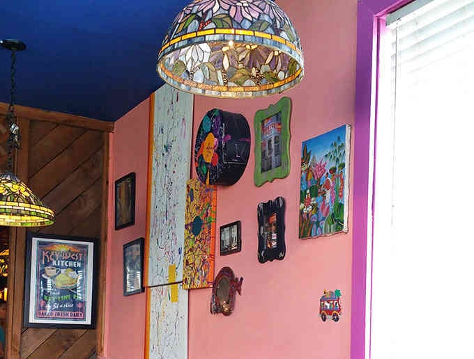 Pink walls adorned with colorful art pieces create a playful backdrop that's Instagram-worthy before Instagram existed.