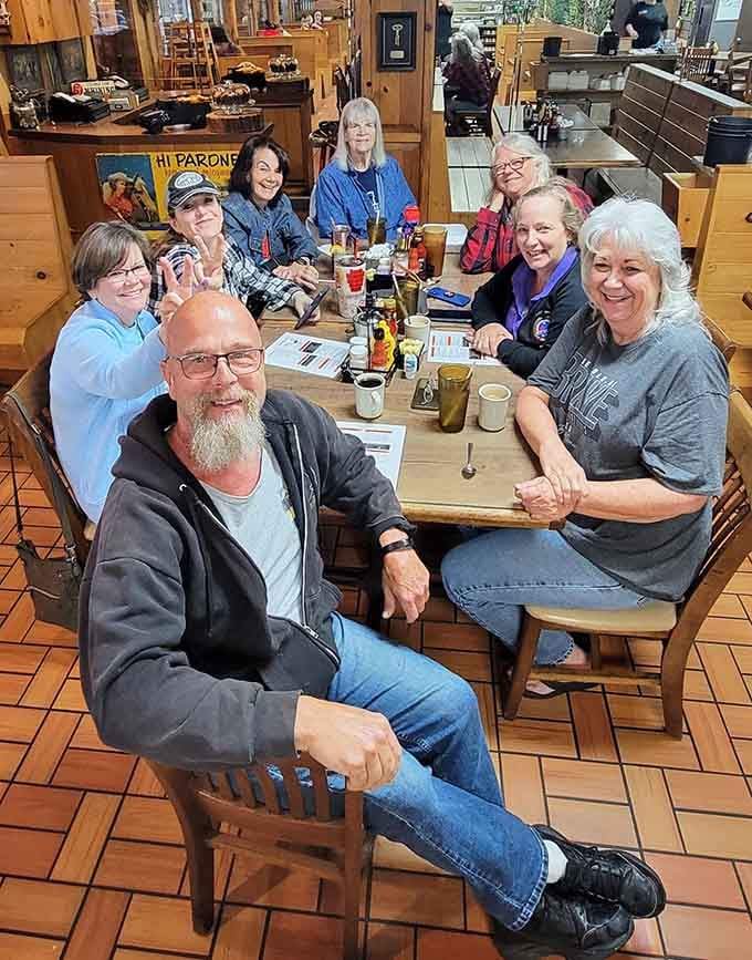 Happy diners gathered around a big table, proof that good food brings people together better than any social media algorithm ever could.