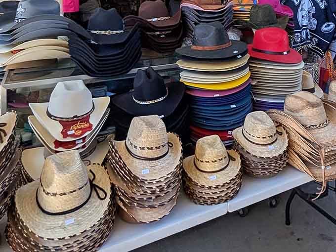 Straw and felt cowboy hats stacked high, offering shade solutions for every head size and style preference.