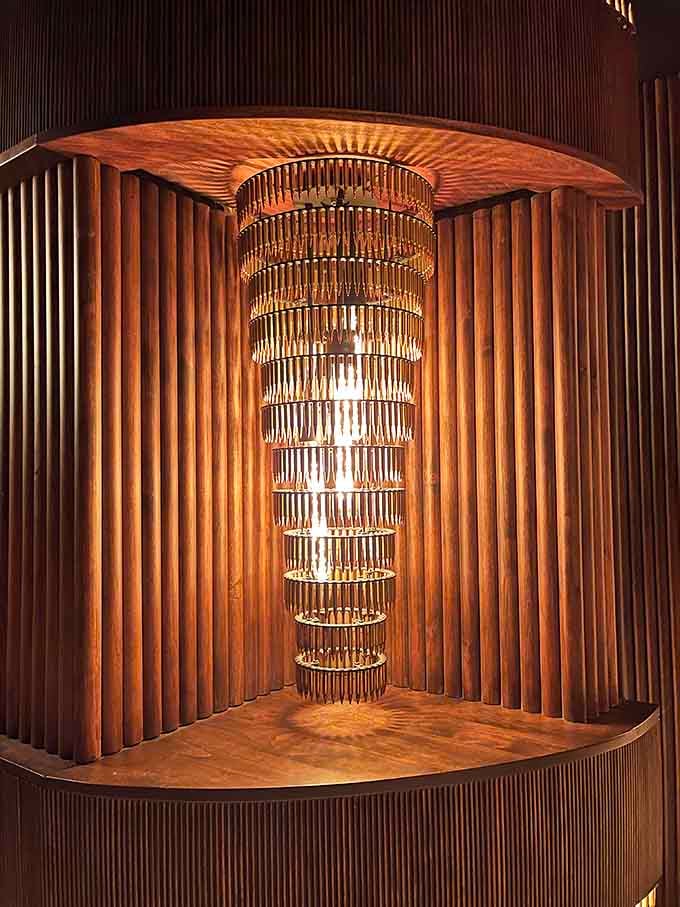 That chandelier installation is pure art, casting shadows and light that make everyone look like they belong in a classic film.