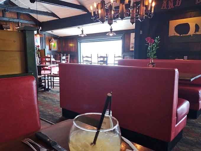 Red booths and natural light create comfortable dining spaces perfect for lingering over that last bite.