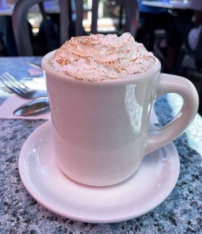 Hot coffee topped with whipped cream and a sprinkle of cocoa, turning your morning caffeine into a proper treat.