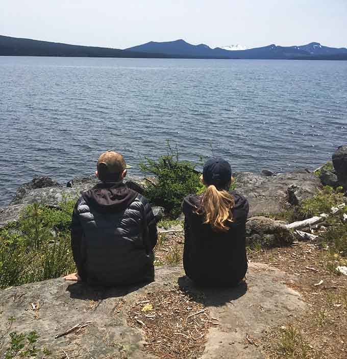 Two visitors contemplate the view, probably discussing whether jumping in that cold water is worth the Instagram post.