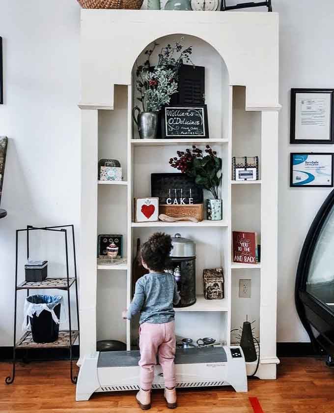 A white arched shelf displaying vintage charm and baking tools, proving that good taste extends beyond the pastries.