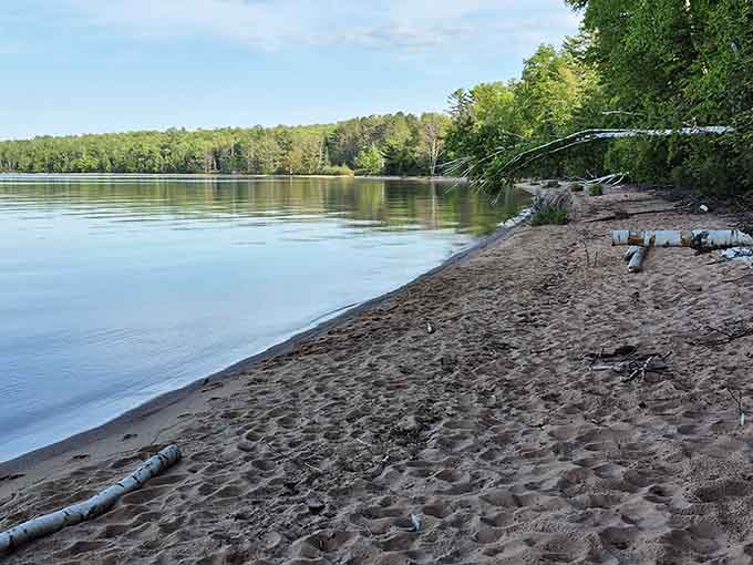 Frog Bay's tranquil shoreline invites quiet contemplation where sand, stone, and Superior waters converge beautifully.
