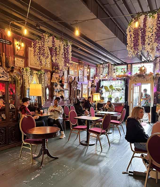 Locals gather beneath floral chandeliers, proving great coffee tastes even better in magical surroundings with good company.