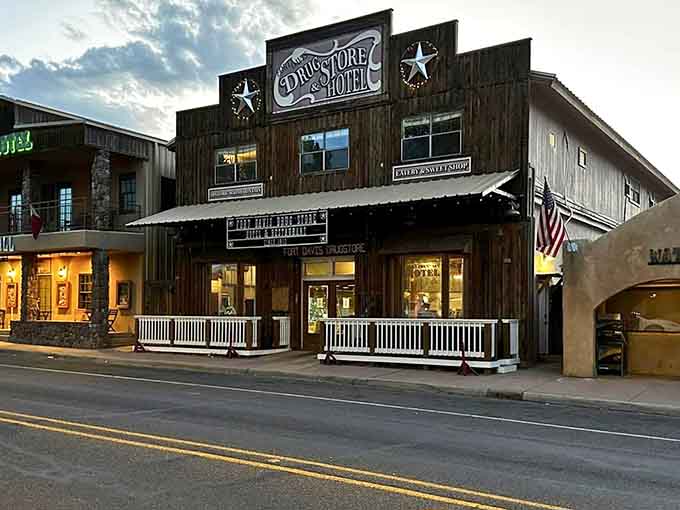The Drugstore Hotel's weathered wood facade glows warmly as evening approaches, inviting travelers to experience authentic frontier hospitality.