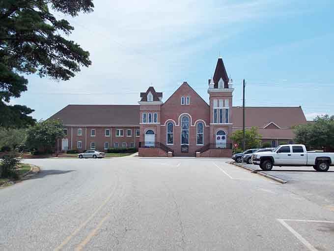 The red brick church with twin towers stands as a testament to faith and craftsmanship that's built to last.