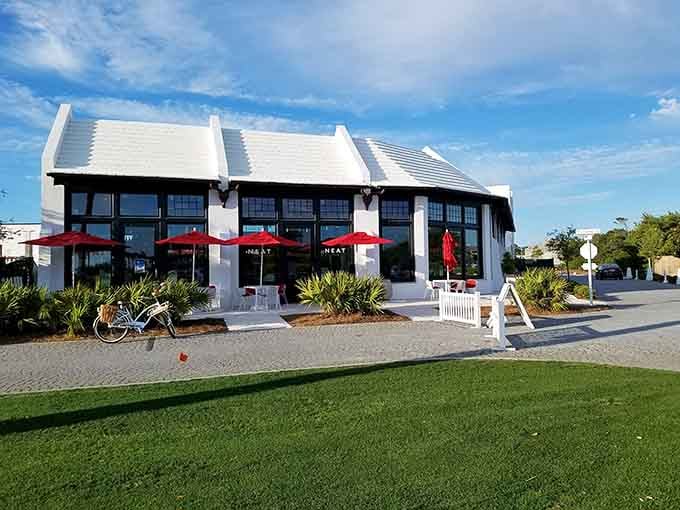 Bright Alys Beach caf&eacute; with white architecture, red umbrellas, and coastal charm invites relaxing moments, sunshine, and easygoing seaside dining experiences.