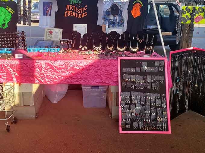 Handmade jewelry on pink-draped tables where "Artistic Creations" means someone actually made these instead of a factory in nowhere.