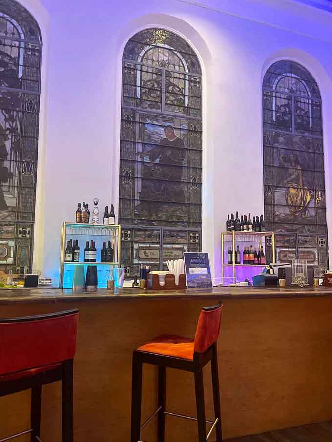 The bar backed by those stunning arched windows, where cocktails are crafted with the same care as everything else here.