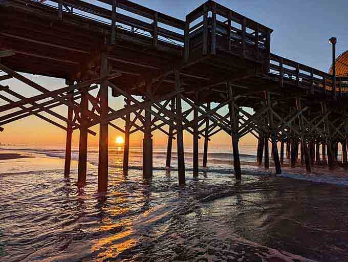 Golden hour beneath the pier is nature's own cathedral, complete with pillars and heavenly light shows.