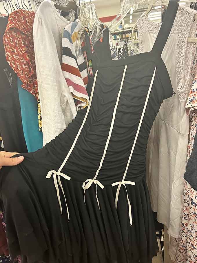 That elegant black dress with white ribbon details could be someone's perfect outfit for weddings, dinners, or special occasions.