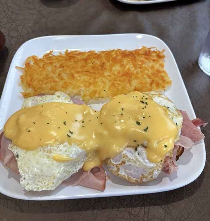 Eggs Benedict smothered in hollandaise sauce with crispy hash browns is breakfast engineering at its finest and most delicious.