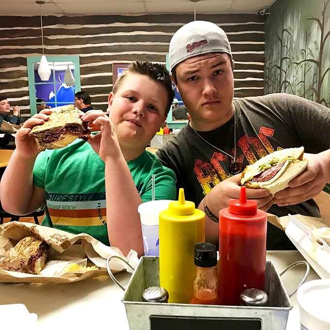 Happy diners showing off their sandwiches like proud parents, and honestly, who could blame them for it?