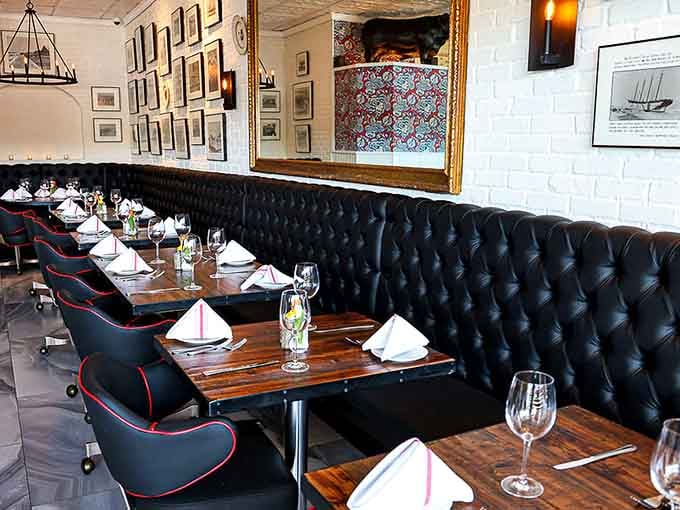 Tufted booths and crisp white napkins create an upscale ambiance that still feels welcoming rather than intimidating or stuffy.
