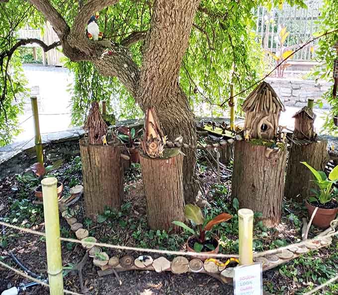 This fairy apartment complex features multiple units with varying architectural styles, like a tiny mixed-use development for the enchanted.