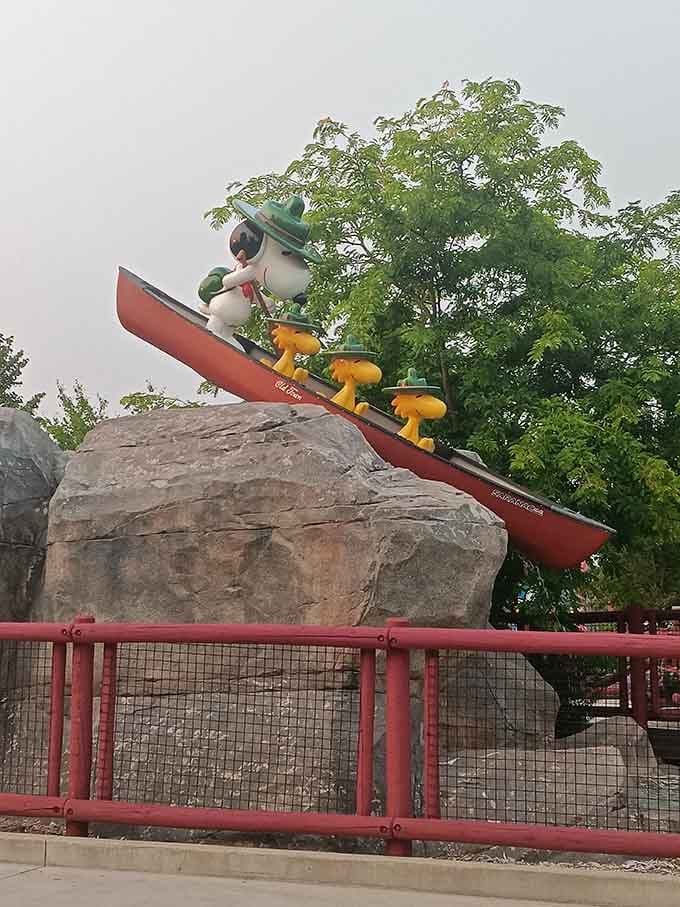 Snoopy conquers the rapids in permanent statue form, forever frozen mid-adventure and looking cooler than most of us ever will.