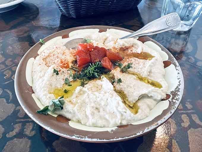 Creamy hummus gets the presentation it deserves, drizzled with olive oil and ready for warm pita bread diving.