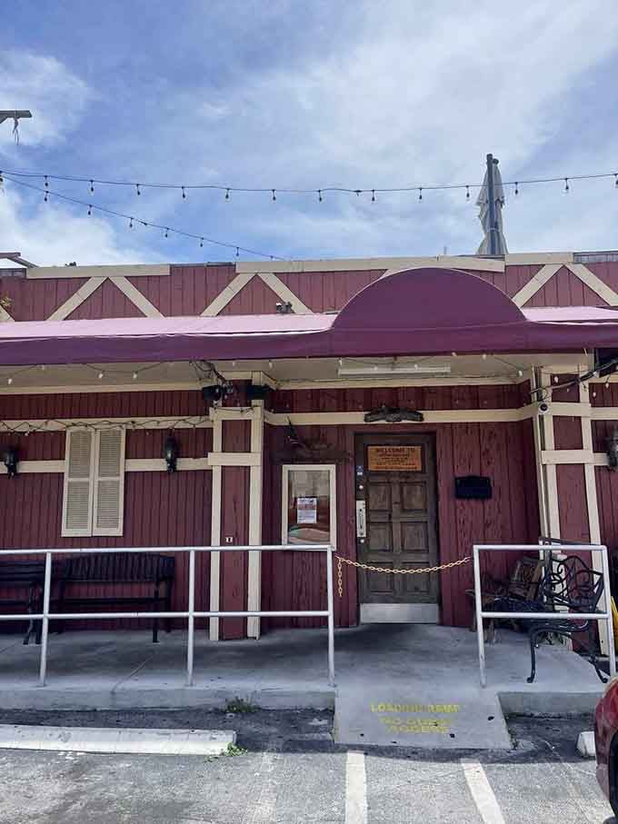 The entrance beckons with string lights overhead, promising comfort food adventures await inside those doors.