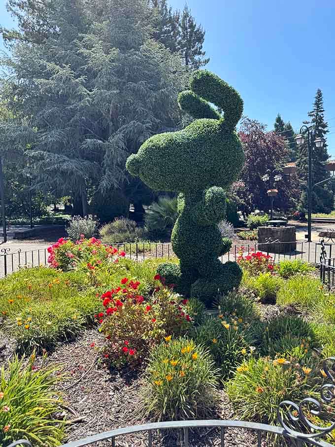 The topiary Snoopy stands guard in the garden, proving great art takes many forms and materials.