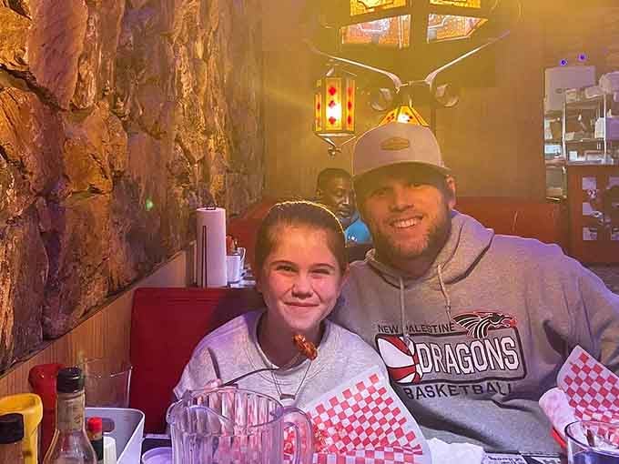 Smiling faces around checkered baskets prove that great food and good company never need a filter to look perfect.