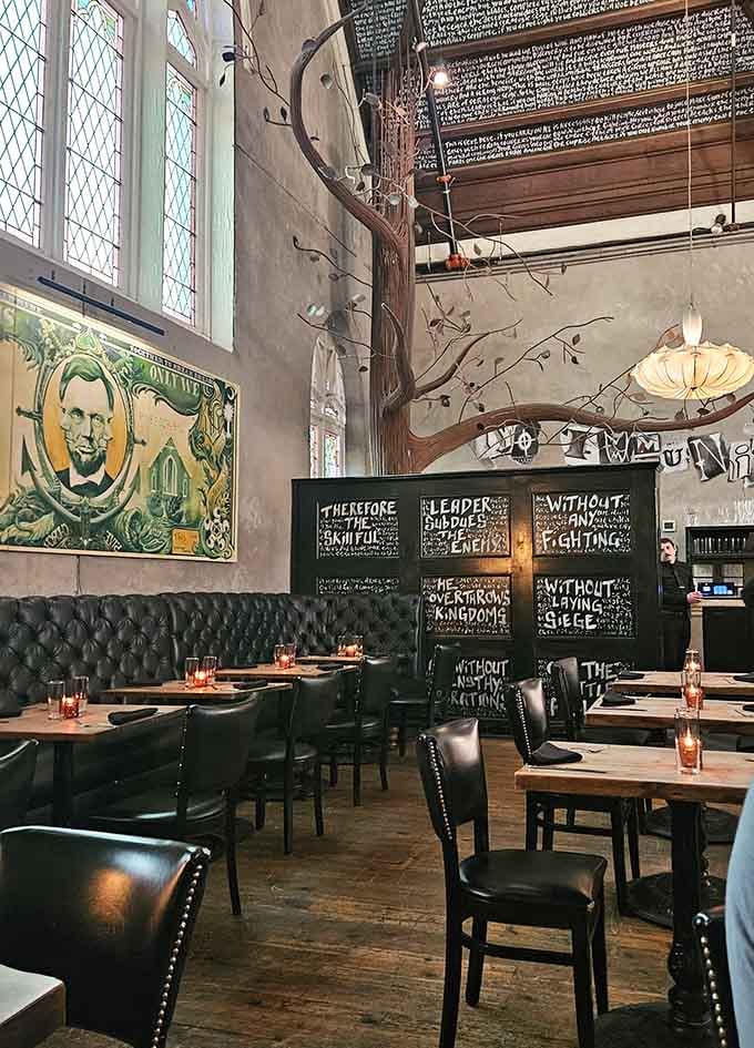 Tufted leather booths beneath arched windows offer cozy spots for lingering over meals in this remarkably transformed worship space.