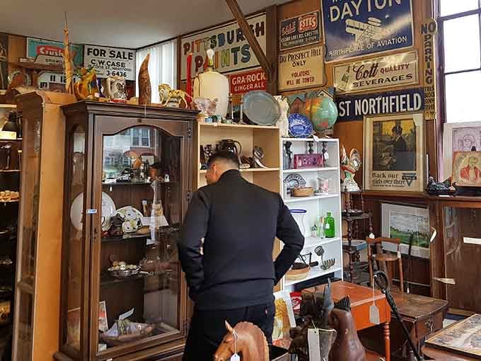A fellow treasure hunter deep in the zone, surrounded by vintage signs and decades of collected American history.