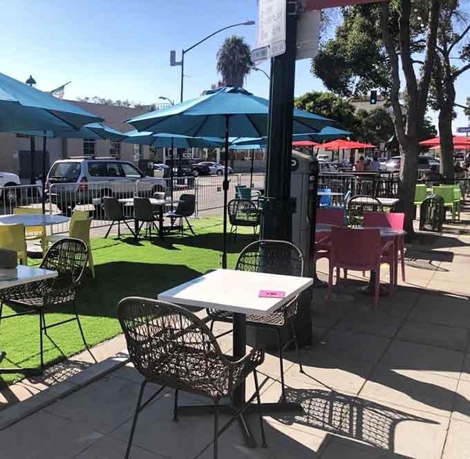 The outdoor patio offers California sunshine and colorful seating, perfect for those who prefer their dining al fresco style.