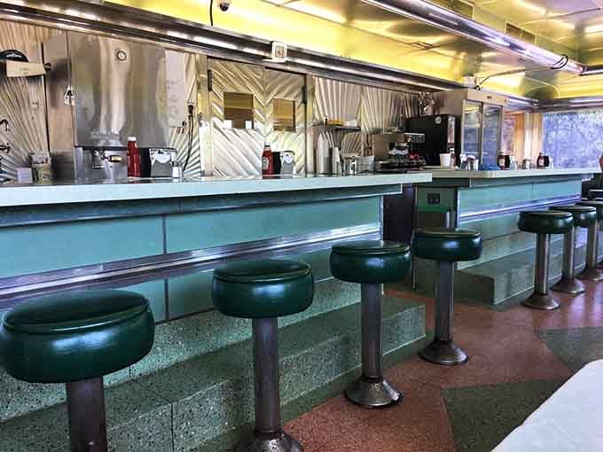 The classic diner counter where you can watch the magic happen while your coffee stays perpetually full.