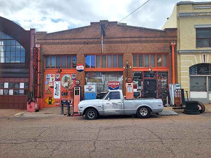 Vintage gas pumps and weathered brick create an automotive still life that belongs in a museum or your camera roll.