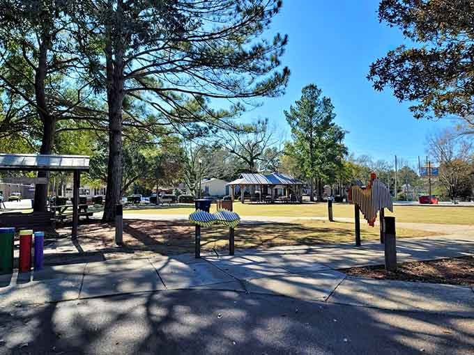 Peaceful pathways wind through well-maintained grounds where community spirit thrives beneath towering Southern trees and blue skies.