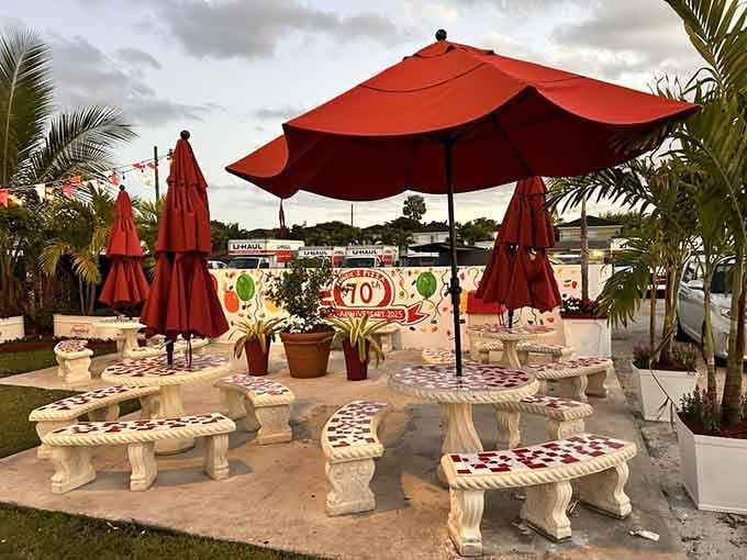 Outdoor seating with red umbrellas and mosaic tables, turning a simple meal into a proper Miami moment.