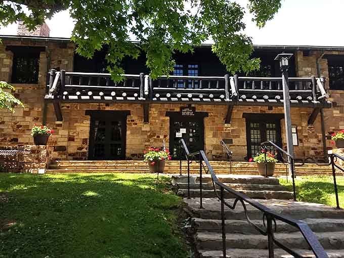The historic lodge stands proud with its stone facade and timber balcony, blending seamlessly into the surrounding woodland.