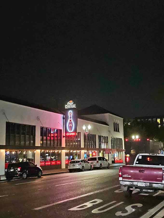The illuminated sign glows against the evening sky, promising good times and great food to everyone passing by below.