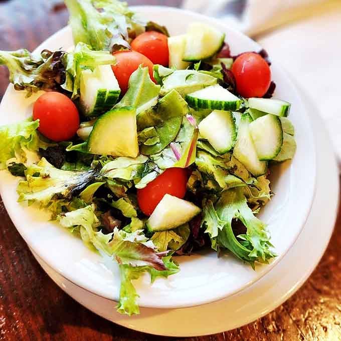Even the salad gets respect here, fresh and colorful with cherry tomatoes brightening every bite.