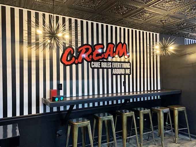 Counter seating beneath bold red lettering reminding you that cake truly does rule everything around here, amen.