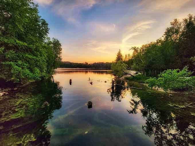 Sunset over the quarry lake looks like someone painted the sky just to make your camera roll jealous.